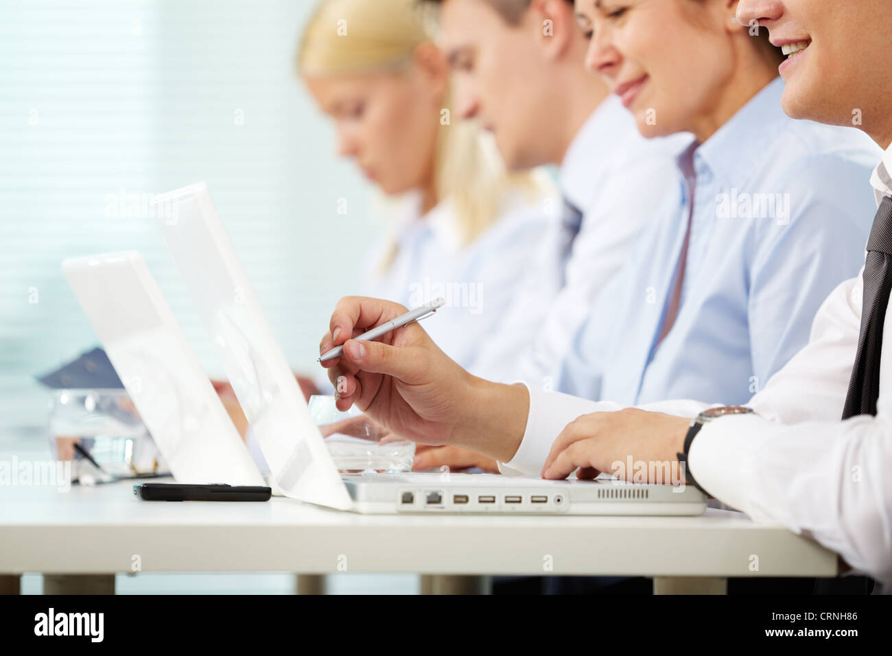 Business people sitting in a row and working Stock Photo - Alamy