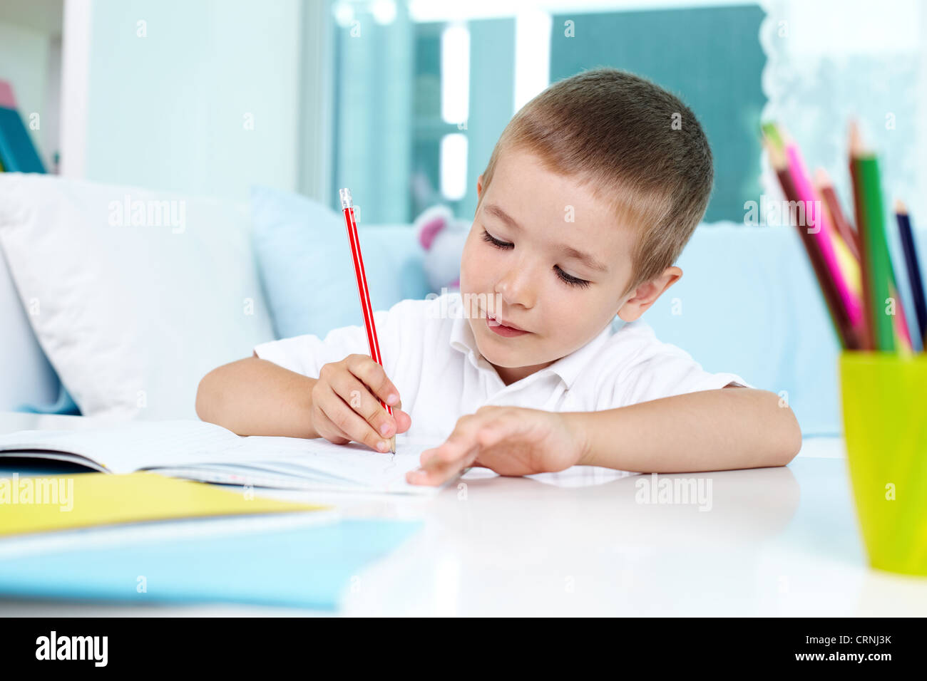 Lovely boy drawing with a pencil Stock Photo - Alamy