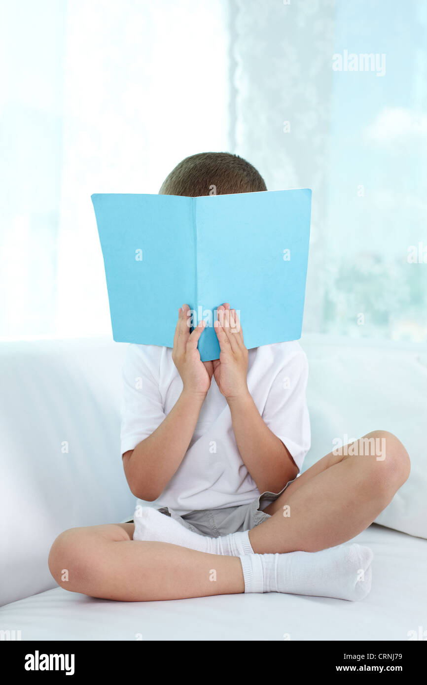 Boy hiding behind book hi-res stock photography and images - Alamy