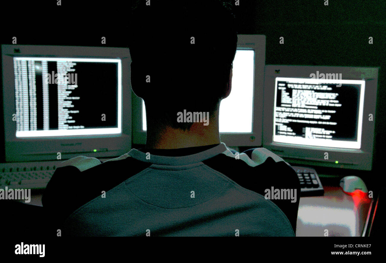 A young man sitting in front of computer monitors Stock Photo - Alamy
