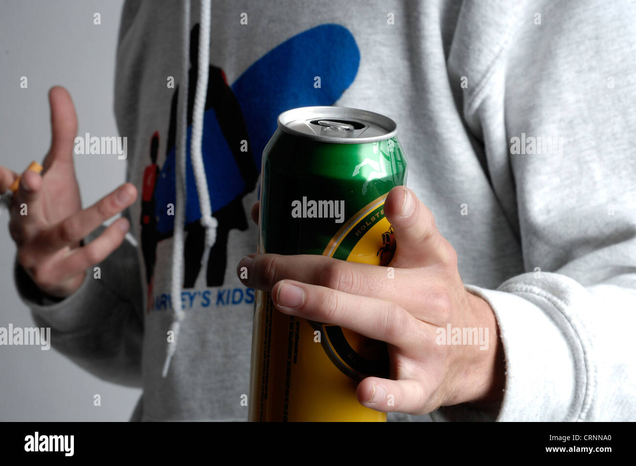 Man holding a beer can in one hand and a cigarette in the other hand ...