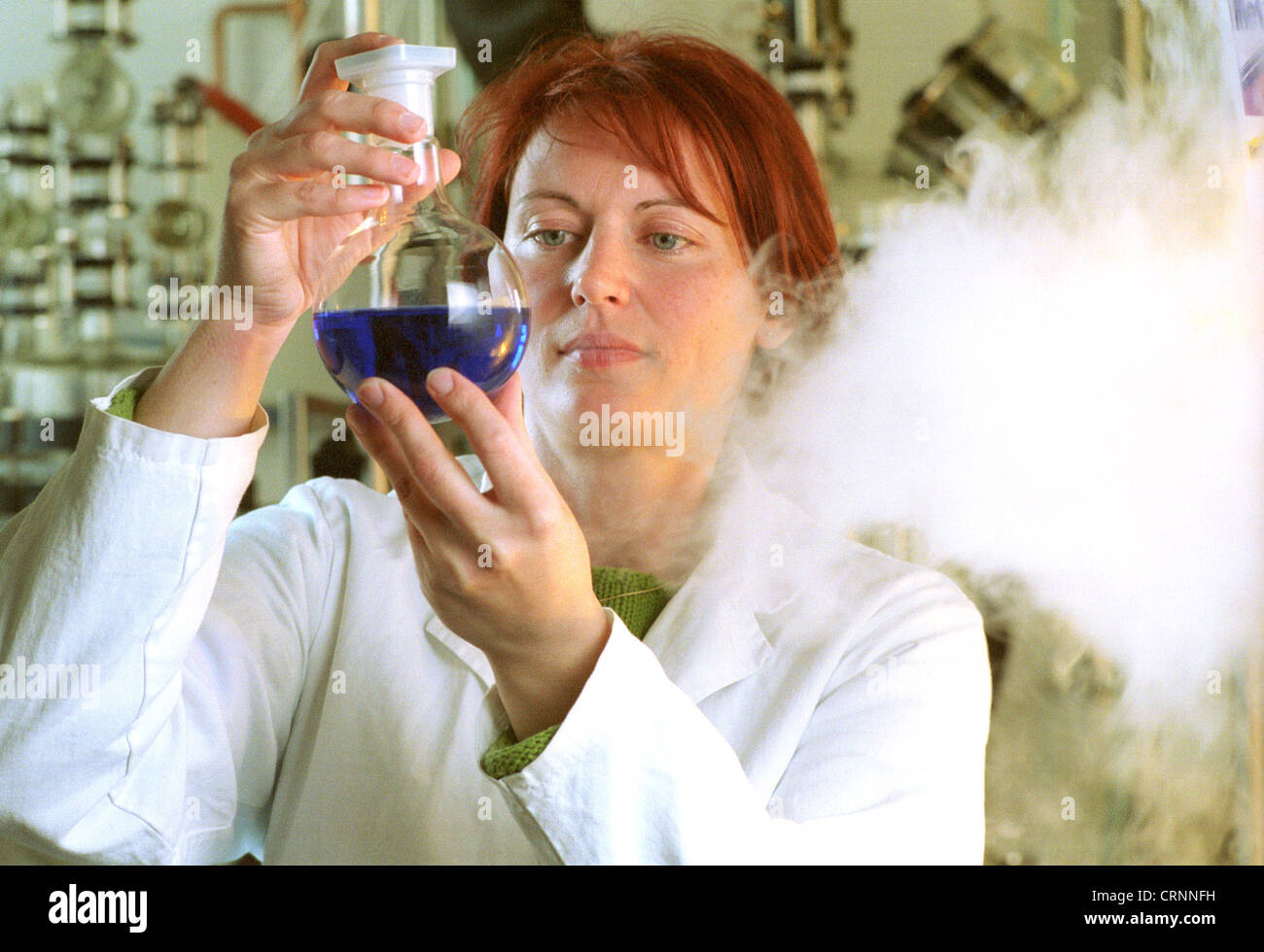 Laboratory assistant with flask and steam Stock Photo - Alamy