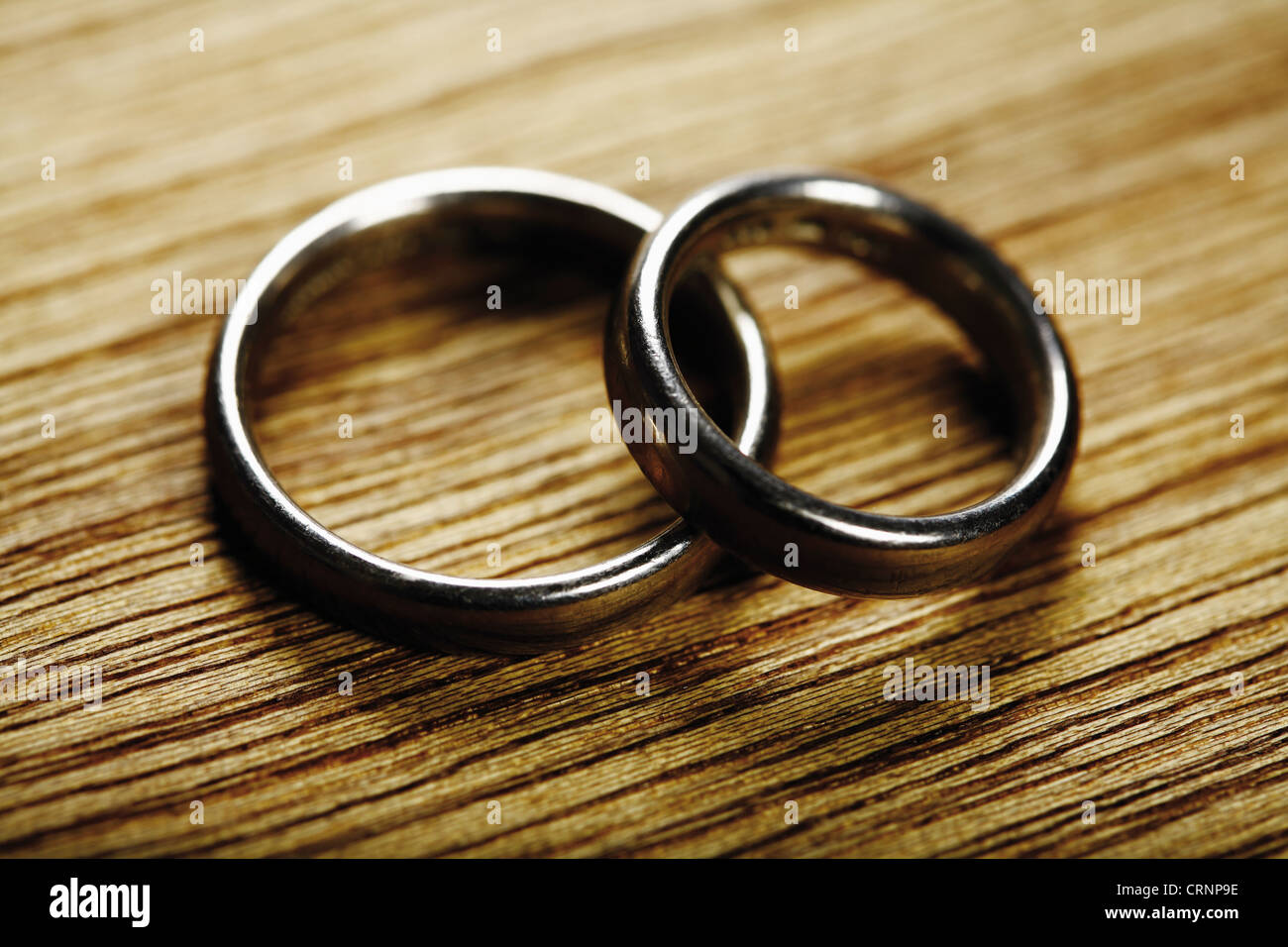 Wedding rings on wooden table Stock Photo - Alamy