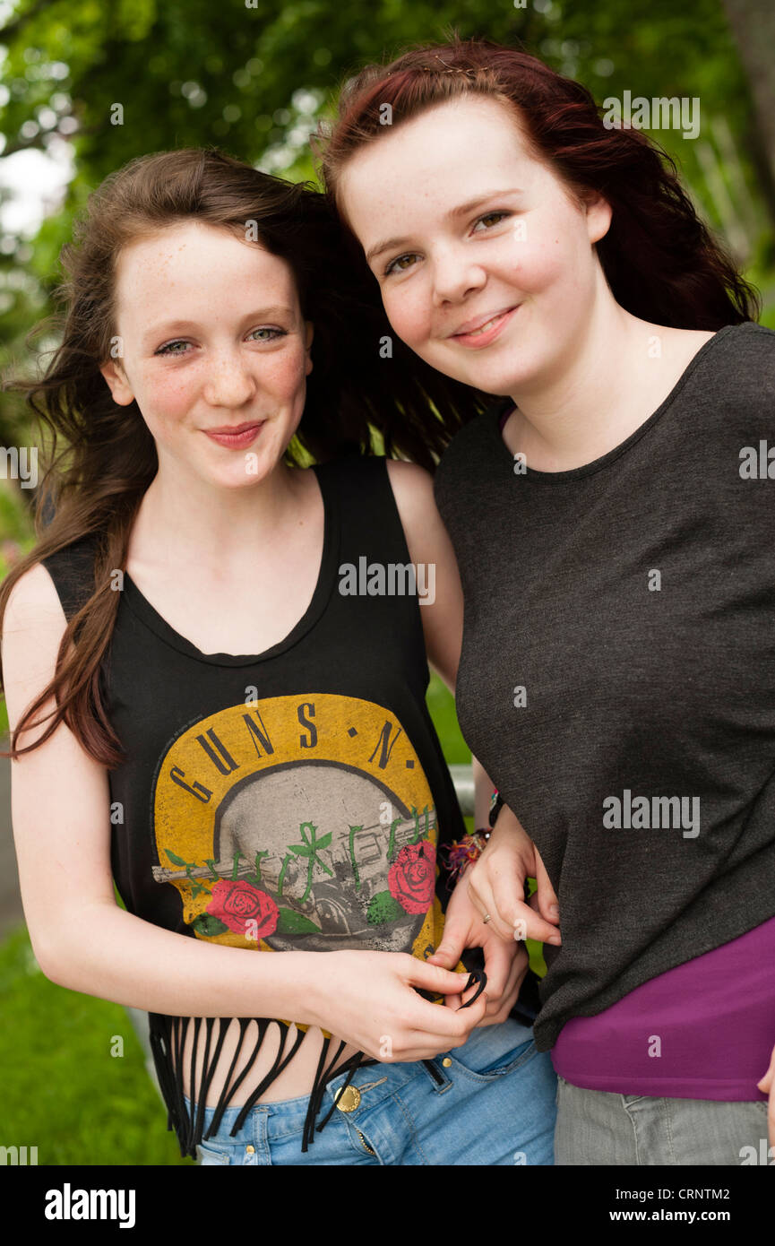 Two happy smiling teen teenage adolescent young girls together outdoors ...