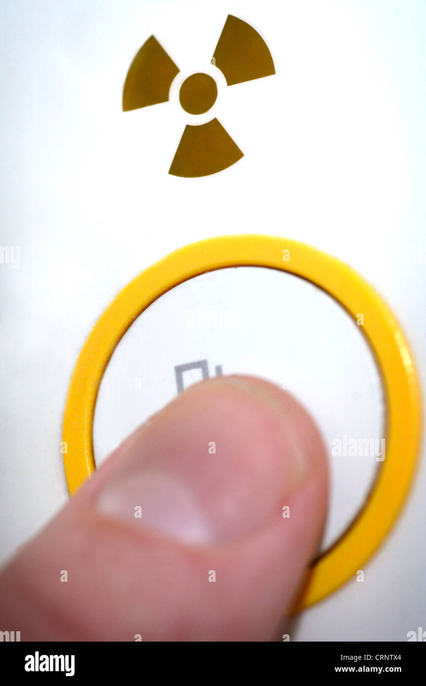 A finger on the start button of an x-ray machine ready to release the ...