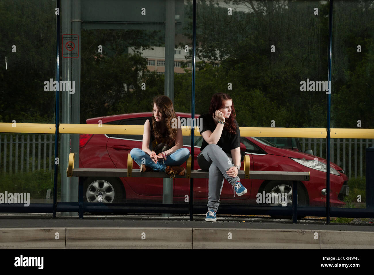 Two bored looking teen teenage adolescent young girls together outdoors ...