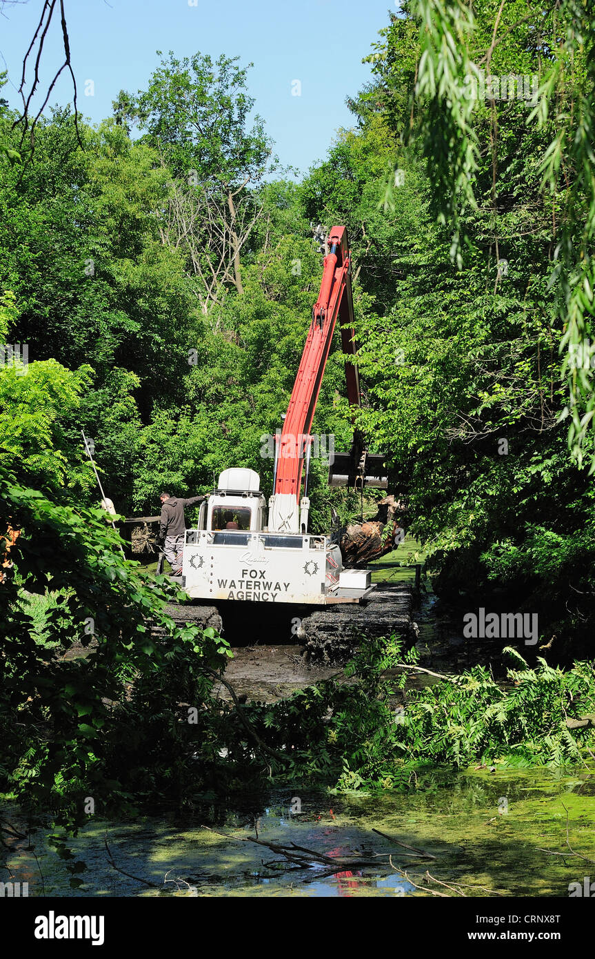 Crane clearing channel debris from an overgrown canal off the Fox River ...