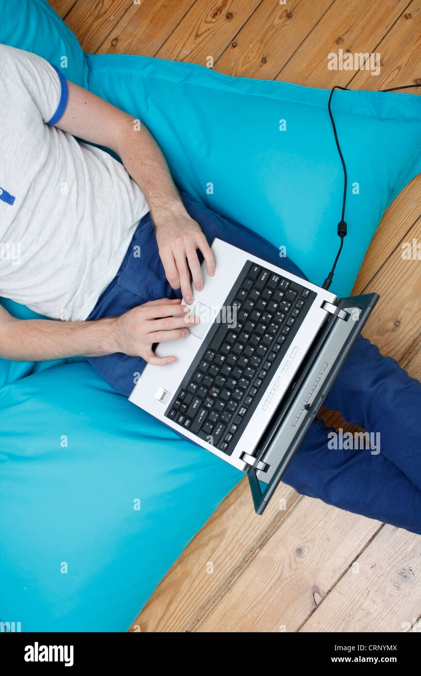 A teenager with a laptop computer on his lap Stock Photo - Alamy