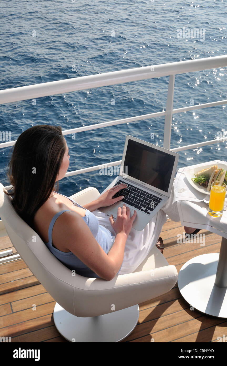 beautiful young woman working at the cruise ship with laptop computer ...