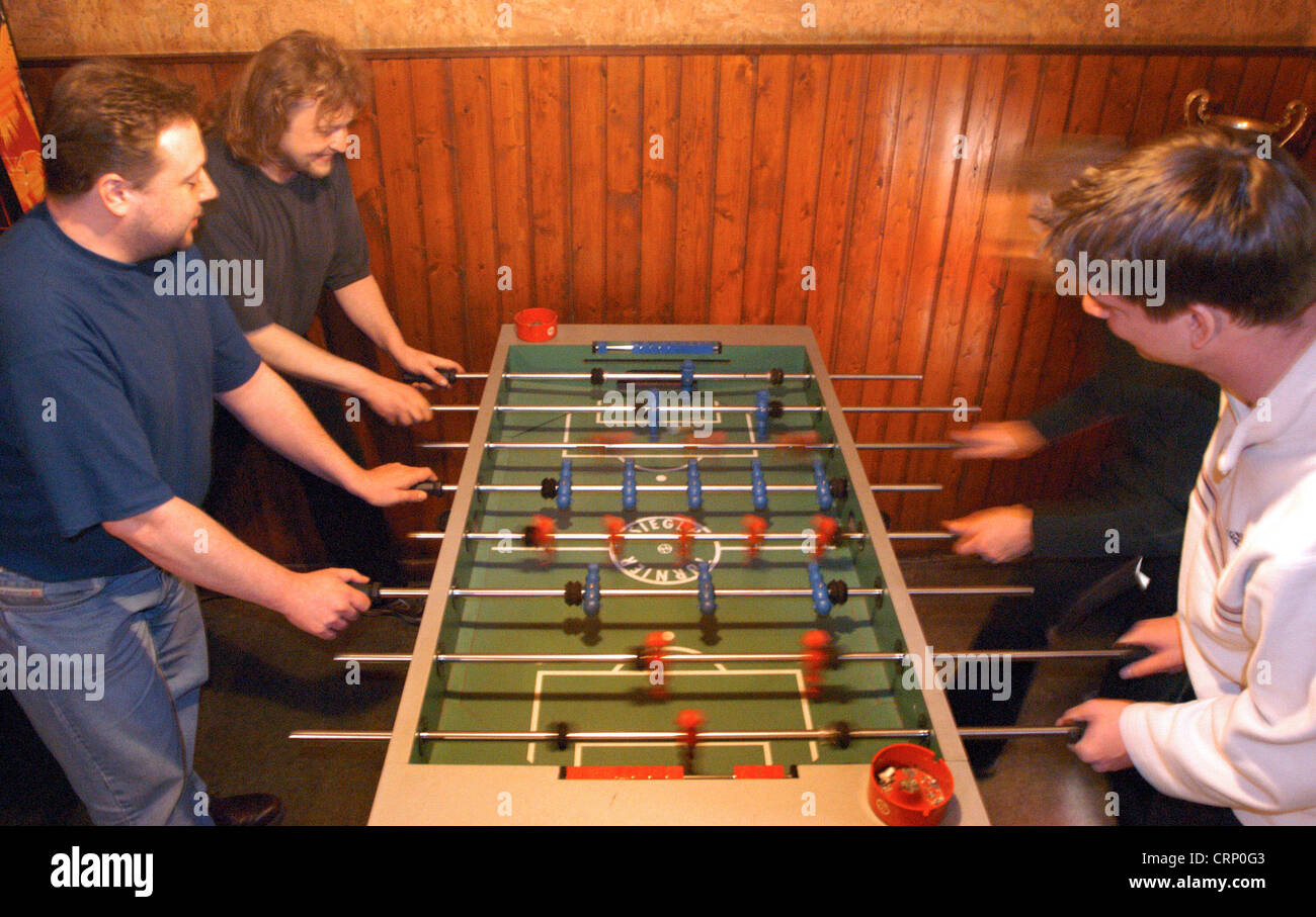 Four men at table football Stock Photo - Alamy