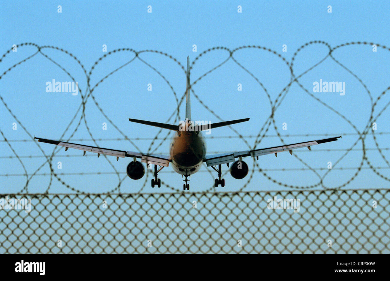 Airplane landing behind a barbed wire fence Stock Photo - Alamy