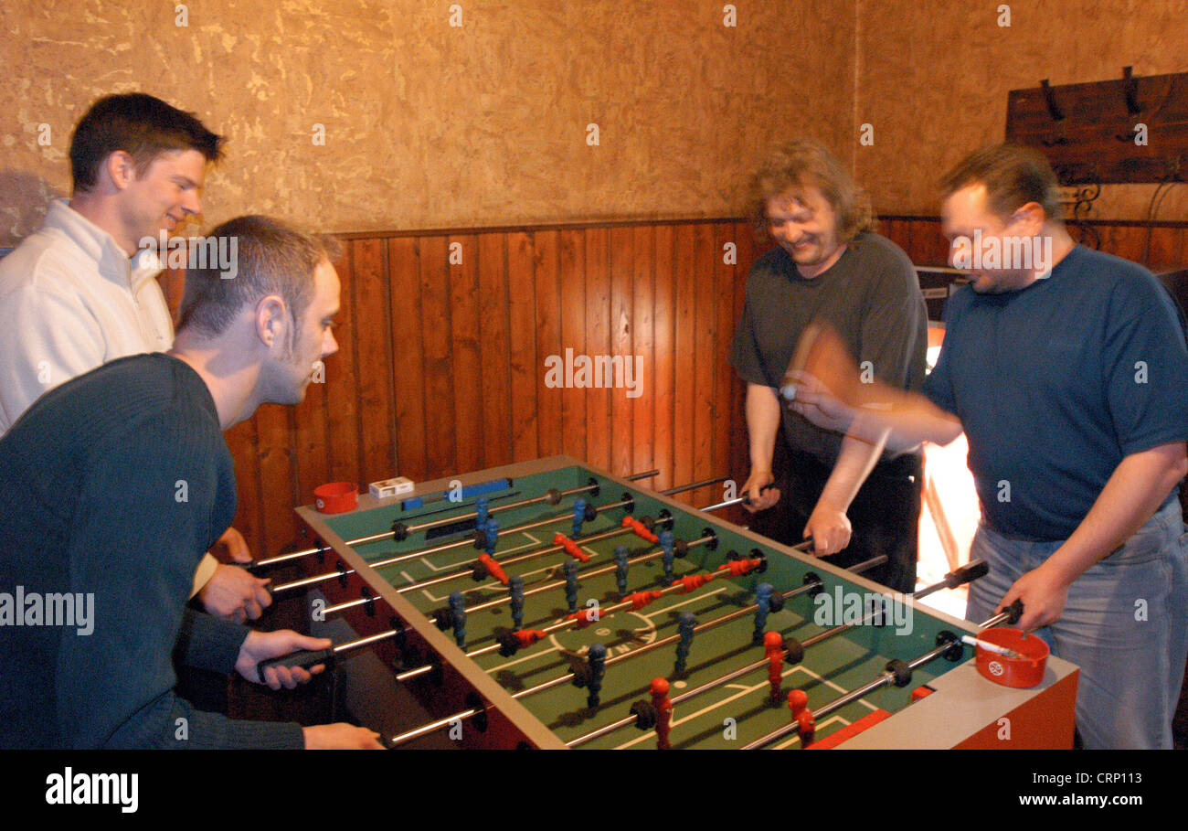 Four men at table football Stock Photo - Alamy