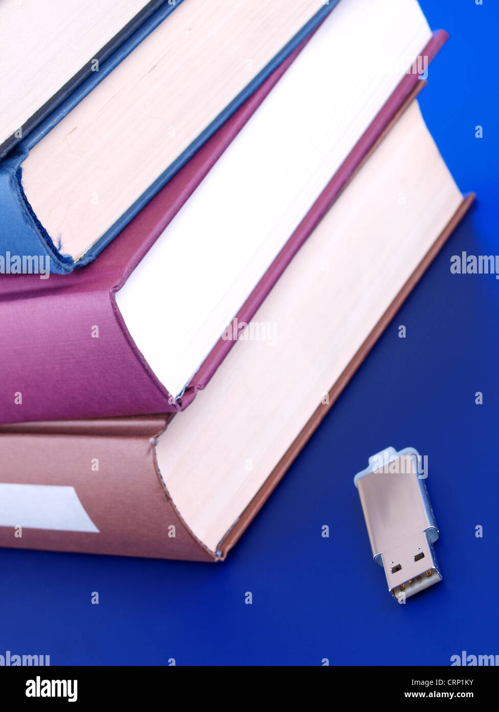 Stack of books with USB memory stick. Blue background Stock Photo - Alamy