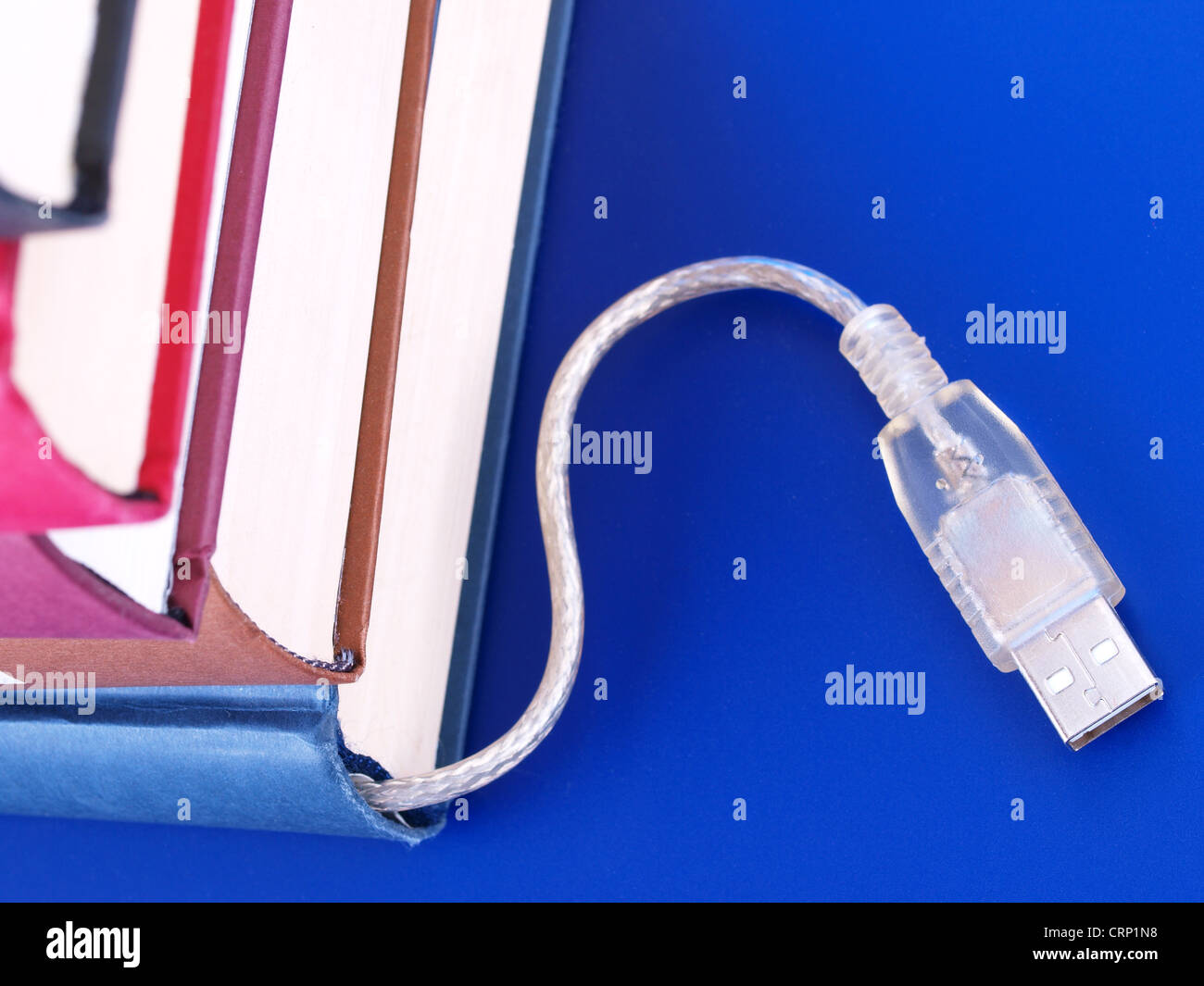 Stack of books with USB connection. Blue background Stock Photo - Alamy