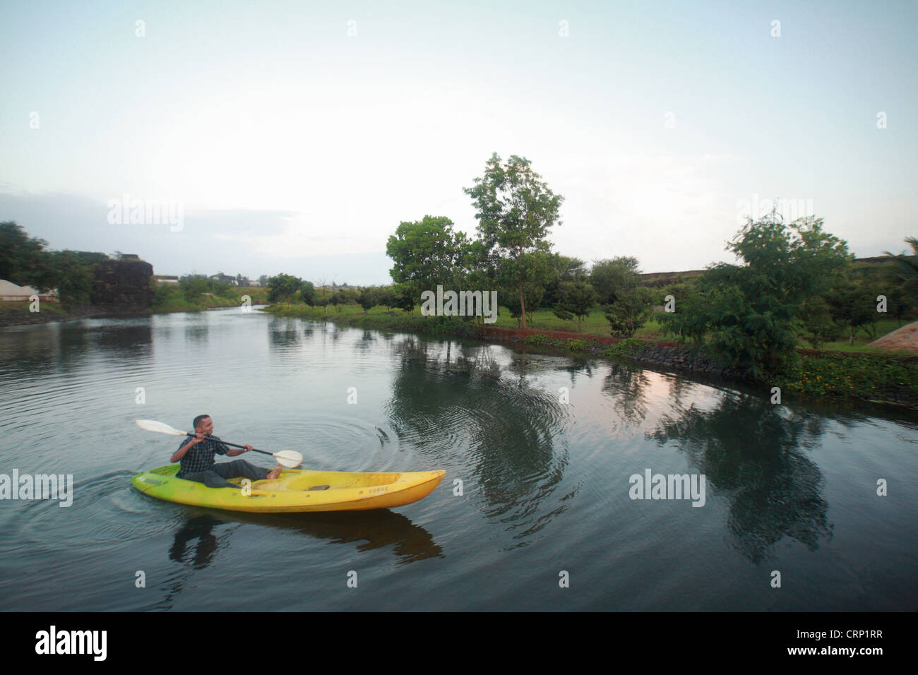 Man on kayak in still water. Canoeing is an outdoor activity that ...