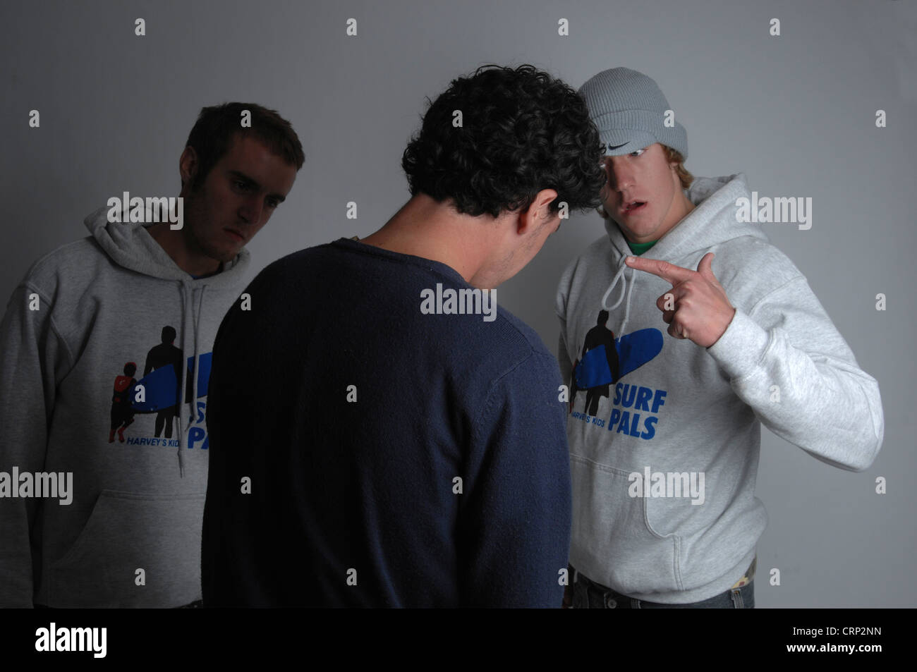 Two angry men confront a young male Stock Photo - Alamy