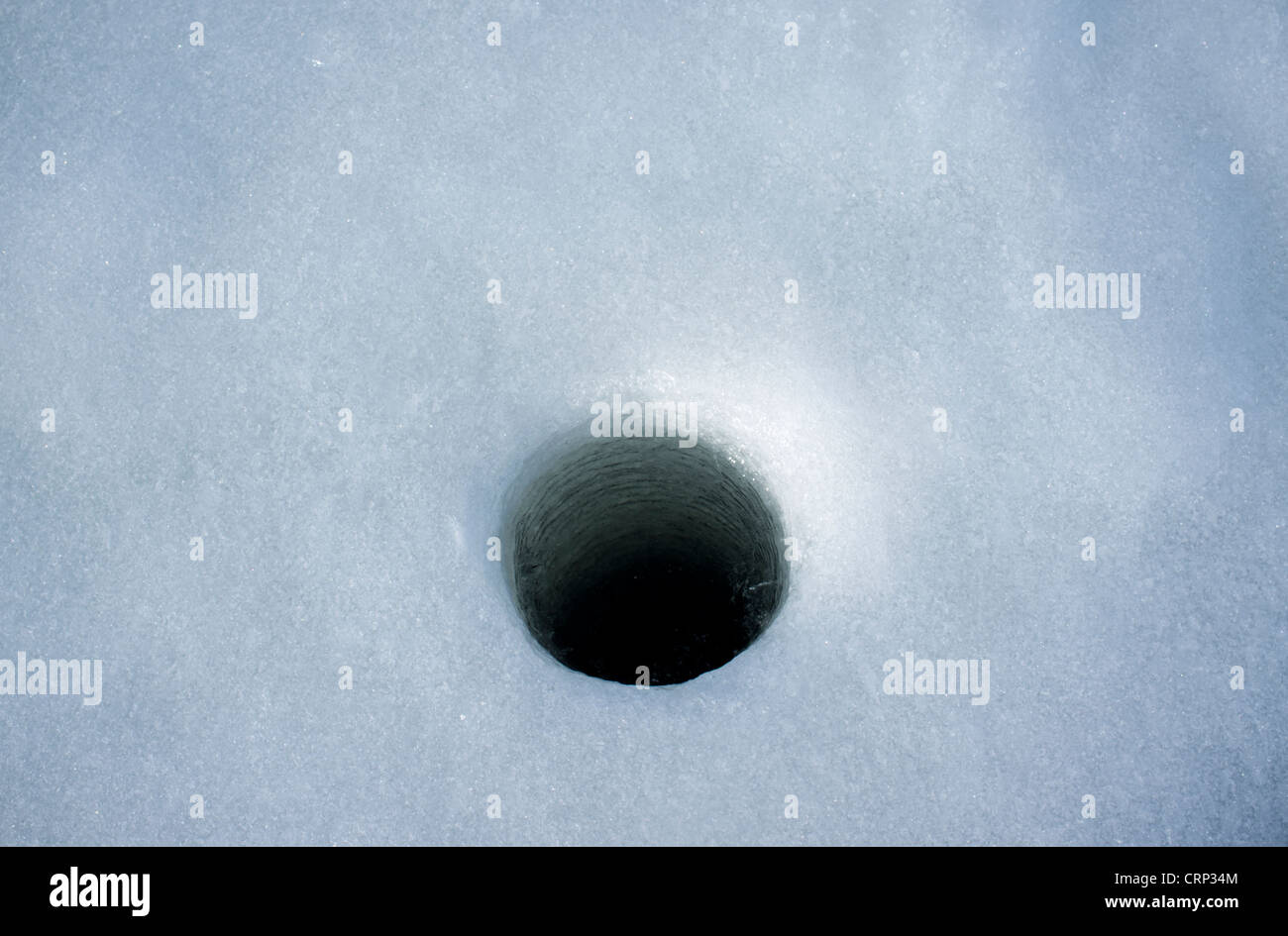 Closeup of an isolated round hole in the ice Stock Photo - Alamy