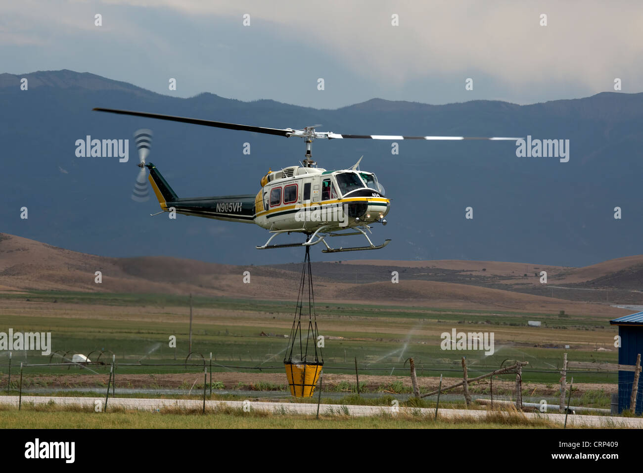 Helicopter aerial forest fighting aircraft filling bucket with water ...