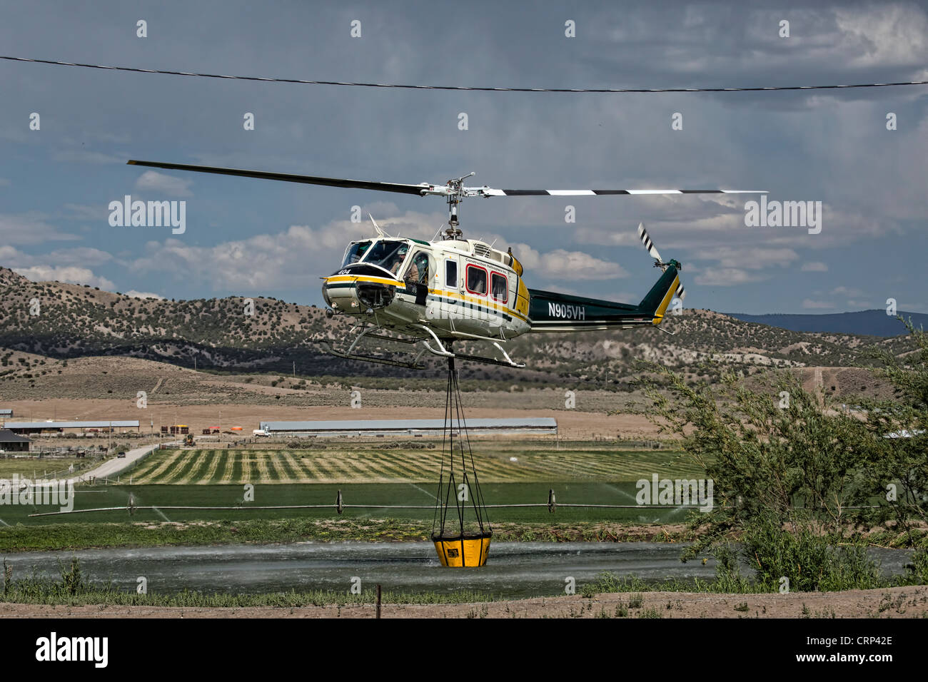 Helicopter aerial forest fighting aircraft filling bucket with water ...