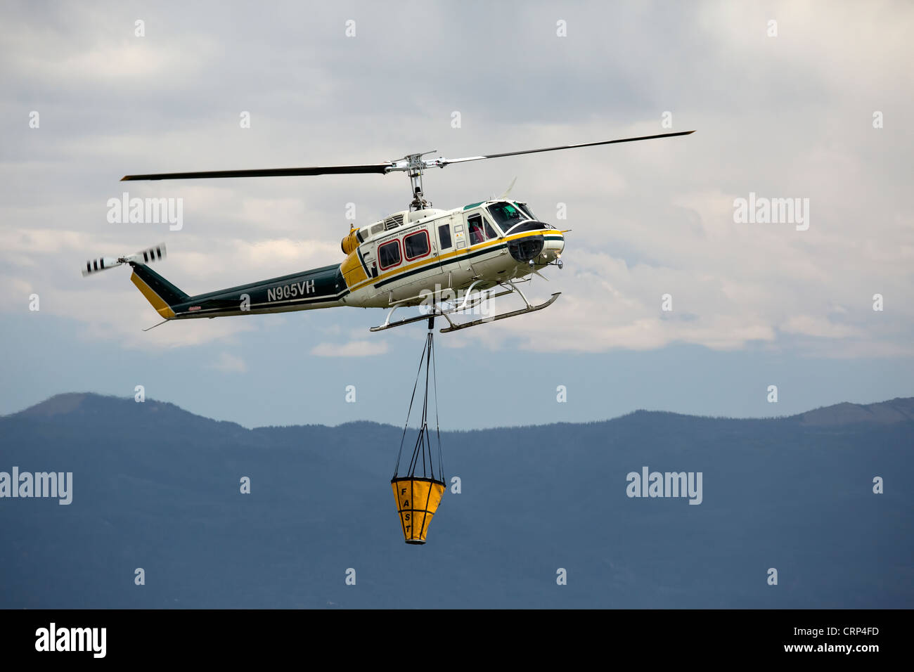 Helicopter aerial forest fighting aircraft filling bucket with water ...