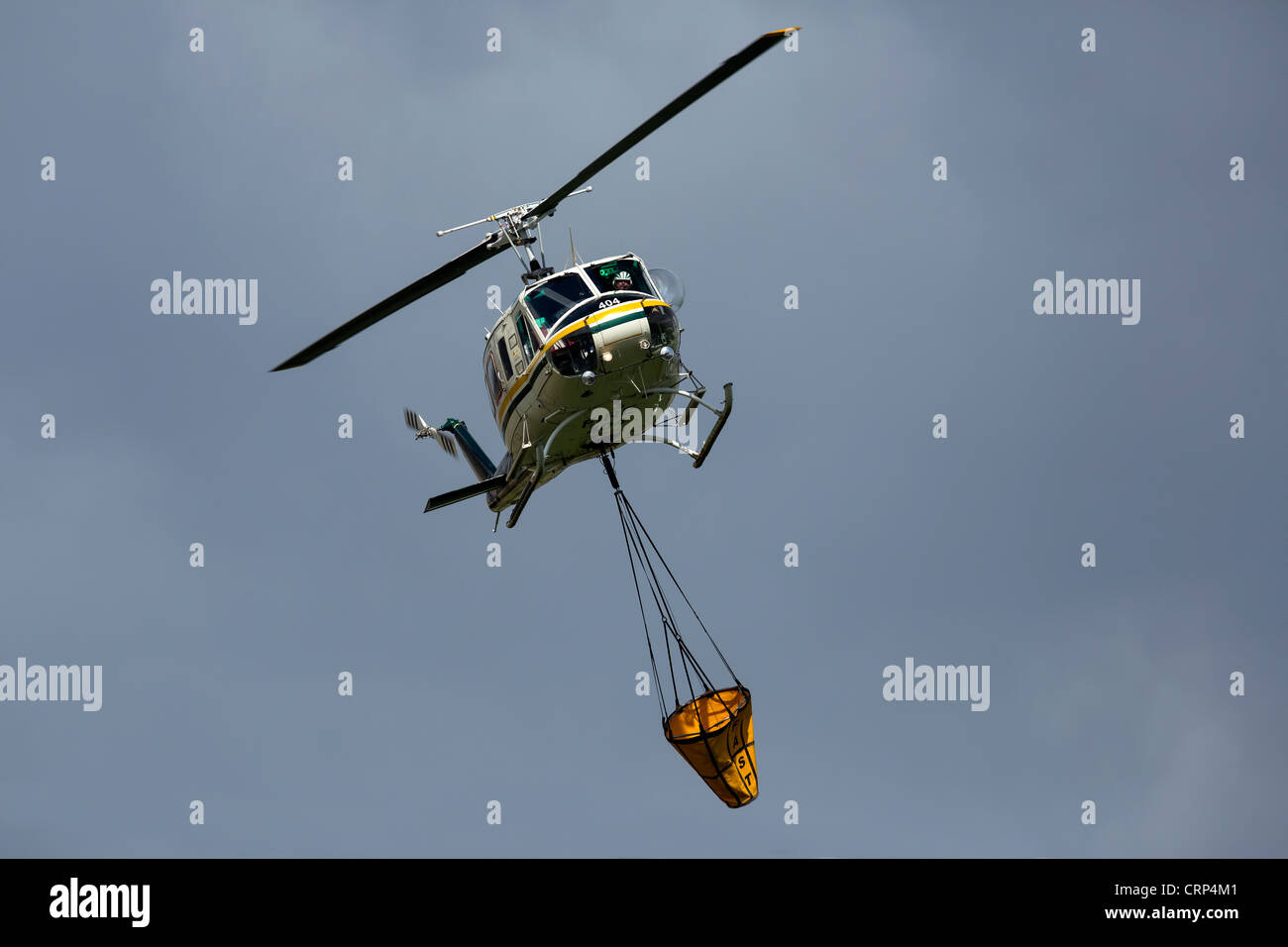 Helicopter aerial forest fighting aircraft filling bucket with water ...