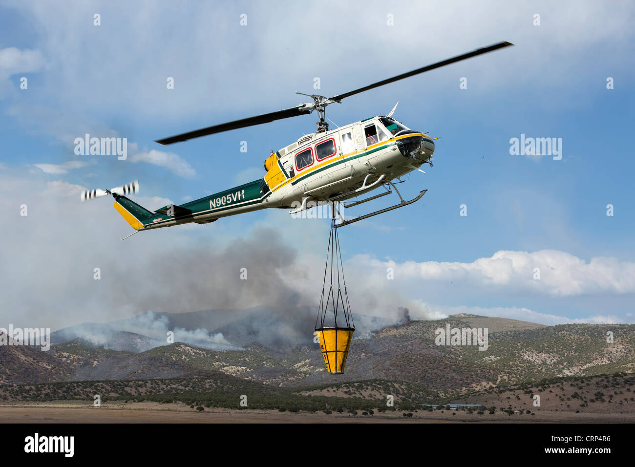 Helicopter aerial forest fighting aircraft filling bucket with water ...