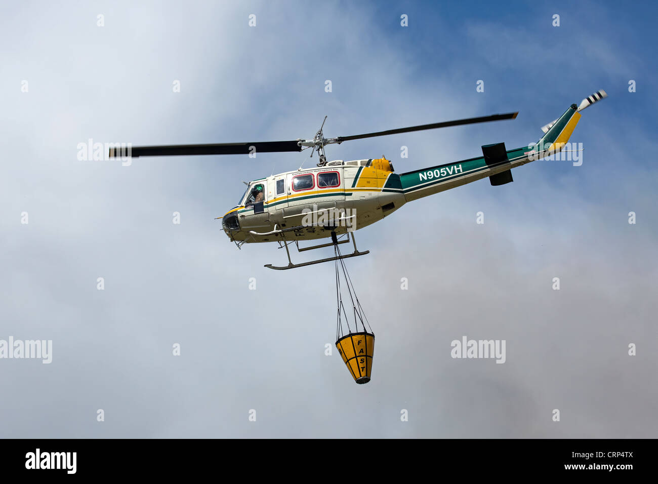 Helicopter aerial forest fighting aircraft filling bucket with water ...