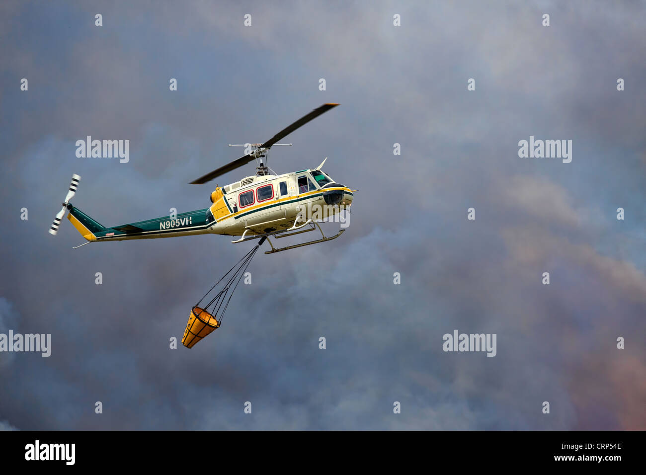 Helicopter aerial forest fighting aircraft filling bucket with water ...