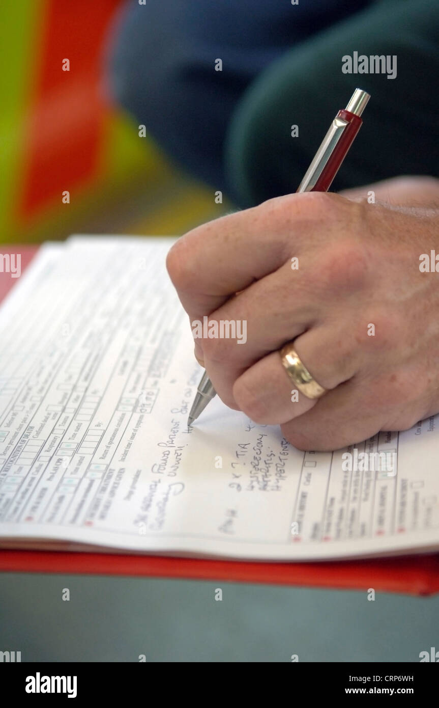 A paramedic from the NHS London Ambulance Service writing up patient ...