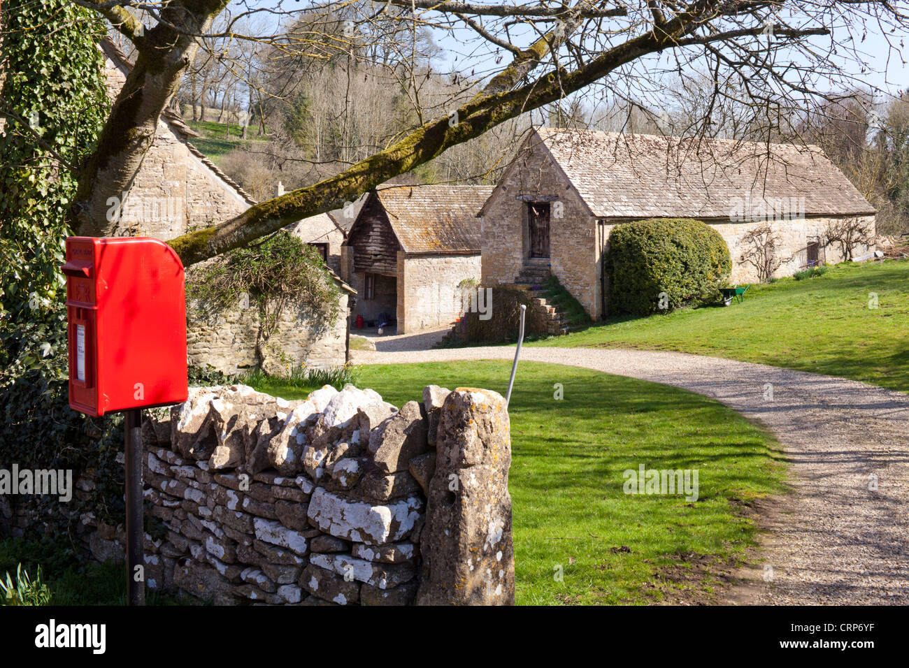 Traditional red British post box in the Cotswold village of ...