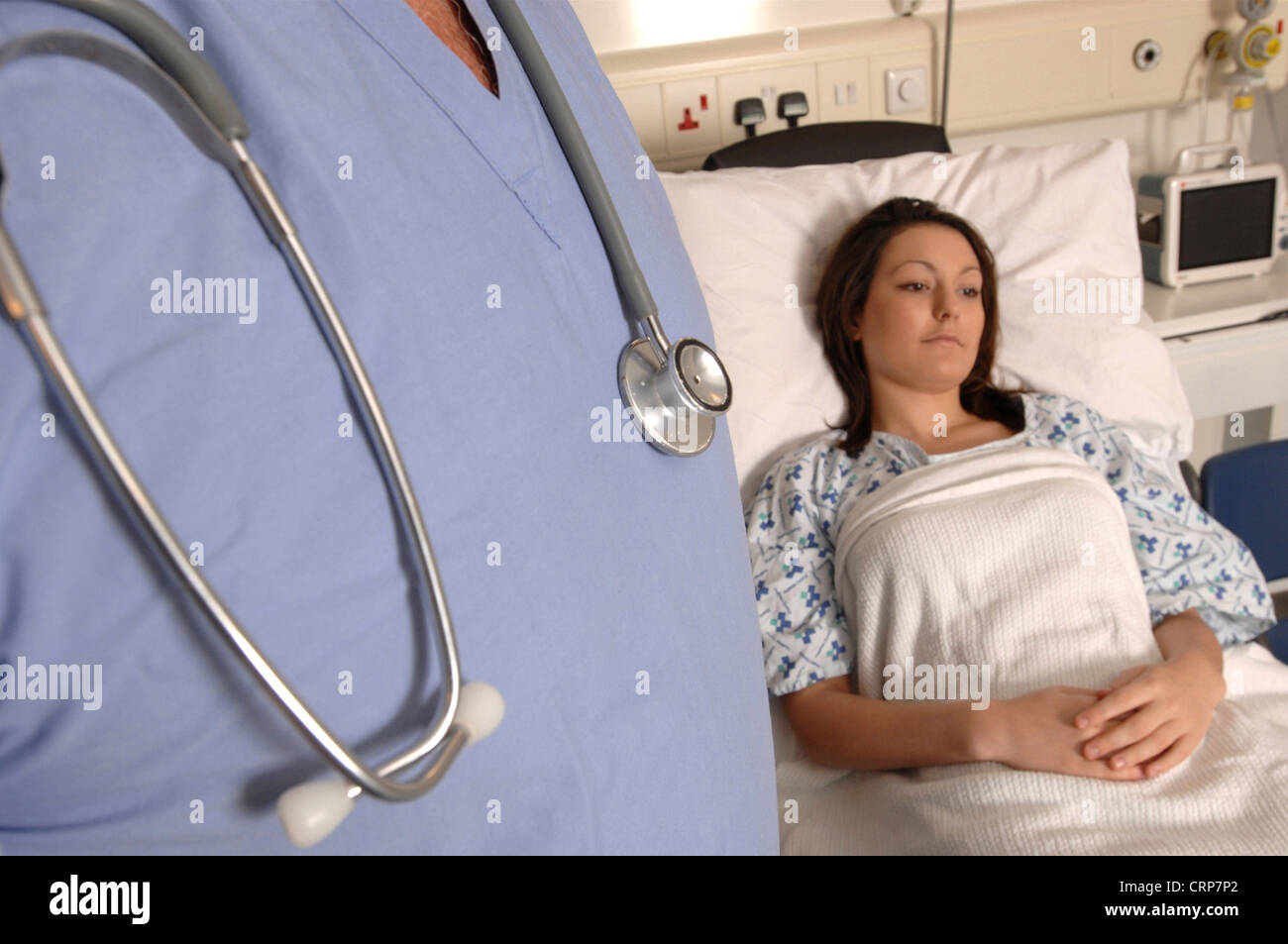 Stethoscope wrapped around a doctor's neck with patient in background ...