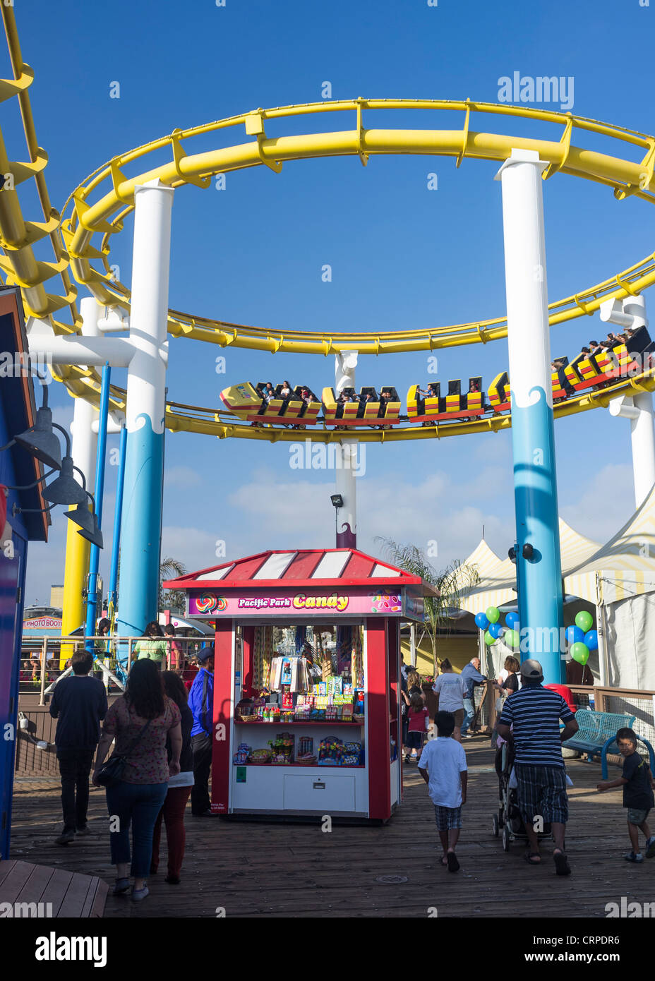 The roller coaster flies above a candy stalll in Pacific Park amusement ...