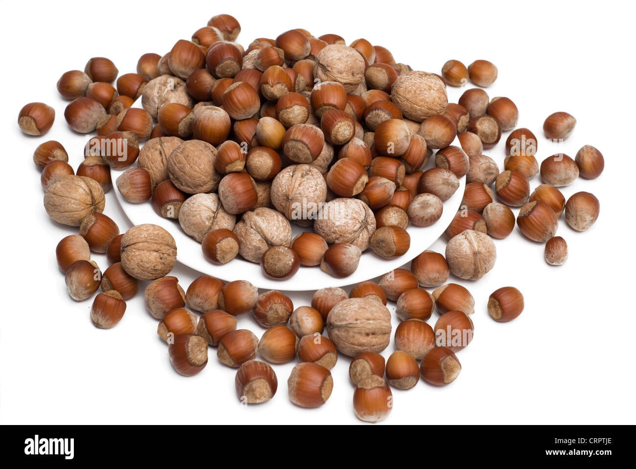 hazelnuts and walnuts in plate over white background Stock Photo - Alamy