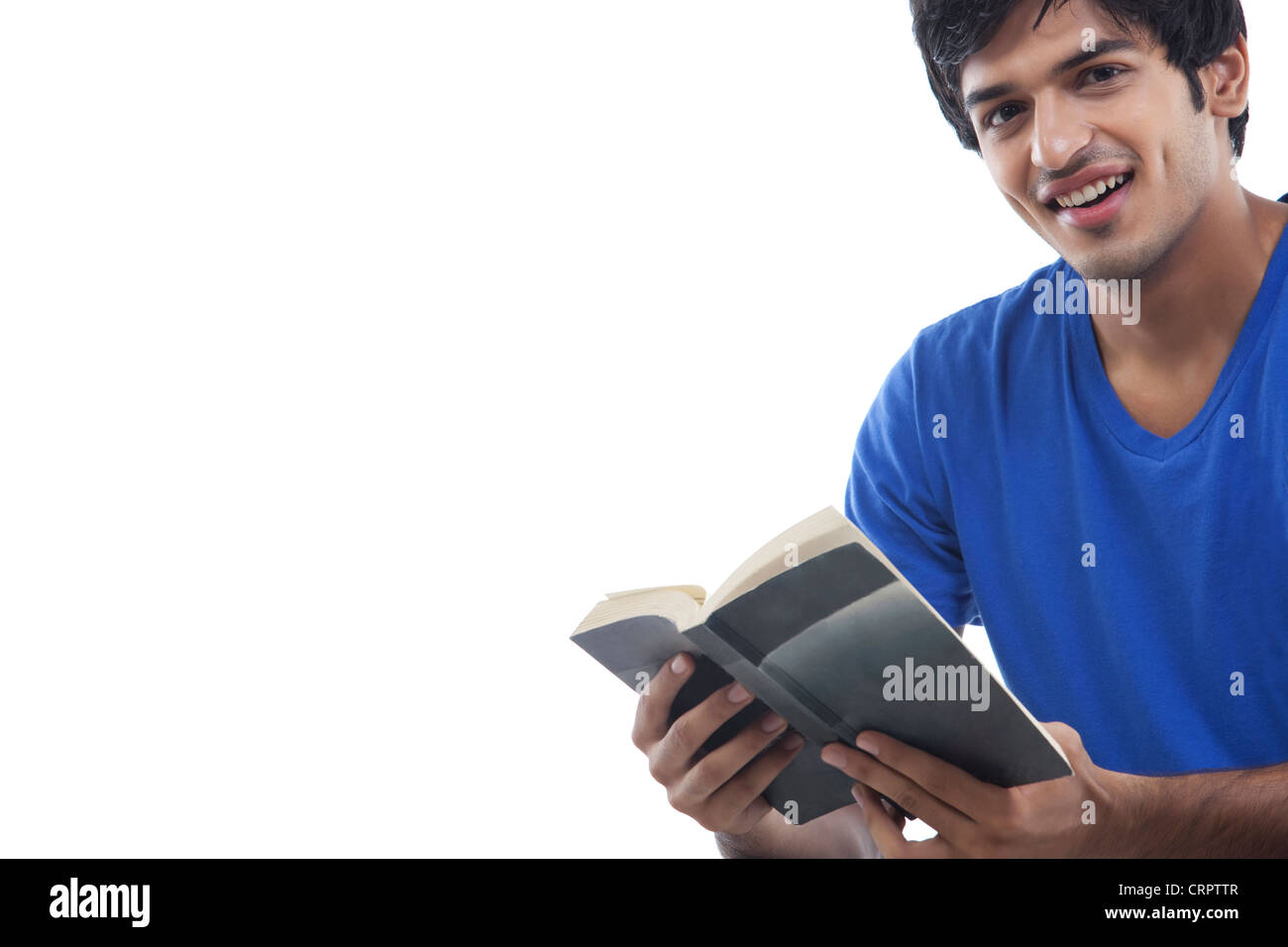 Portrait of smiling young man reading book over white background Stock ...
