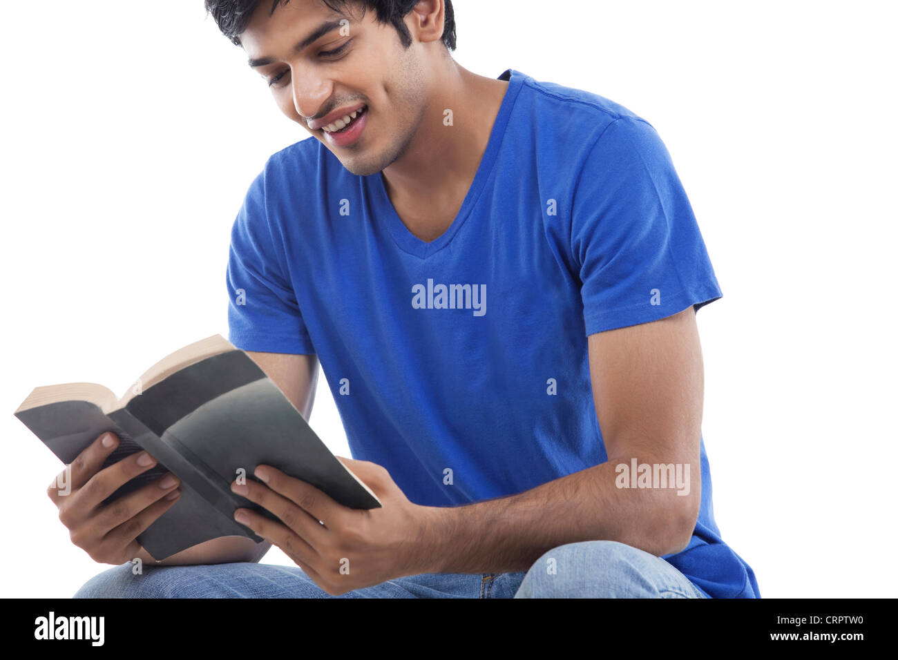 Young man enjoying reading book over white background Stock Photo - Alamy