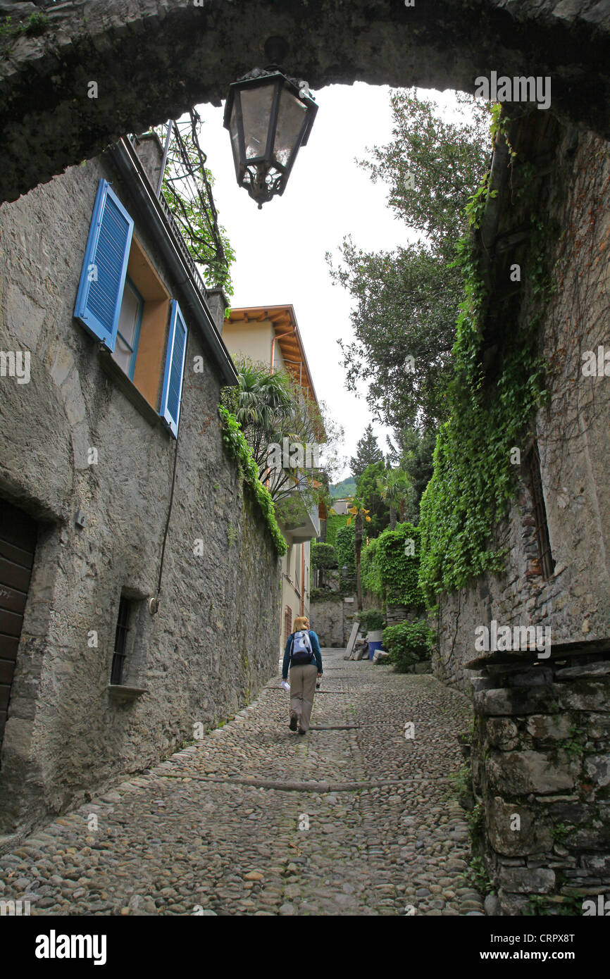 A woman walking up the quaint narrow steep cobbled streets of the town ...