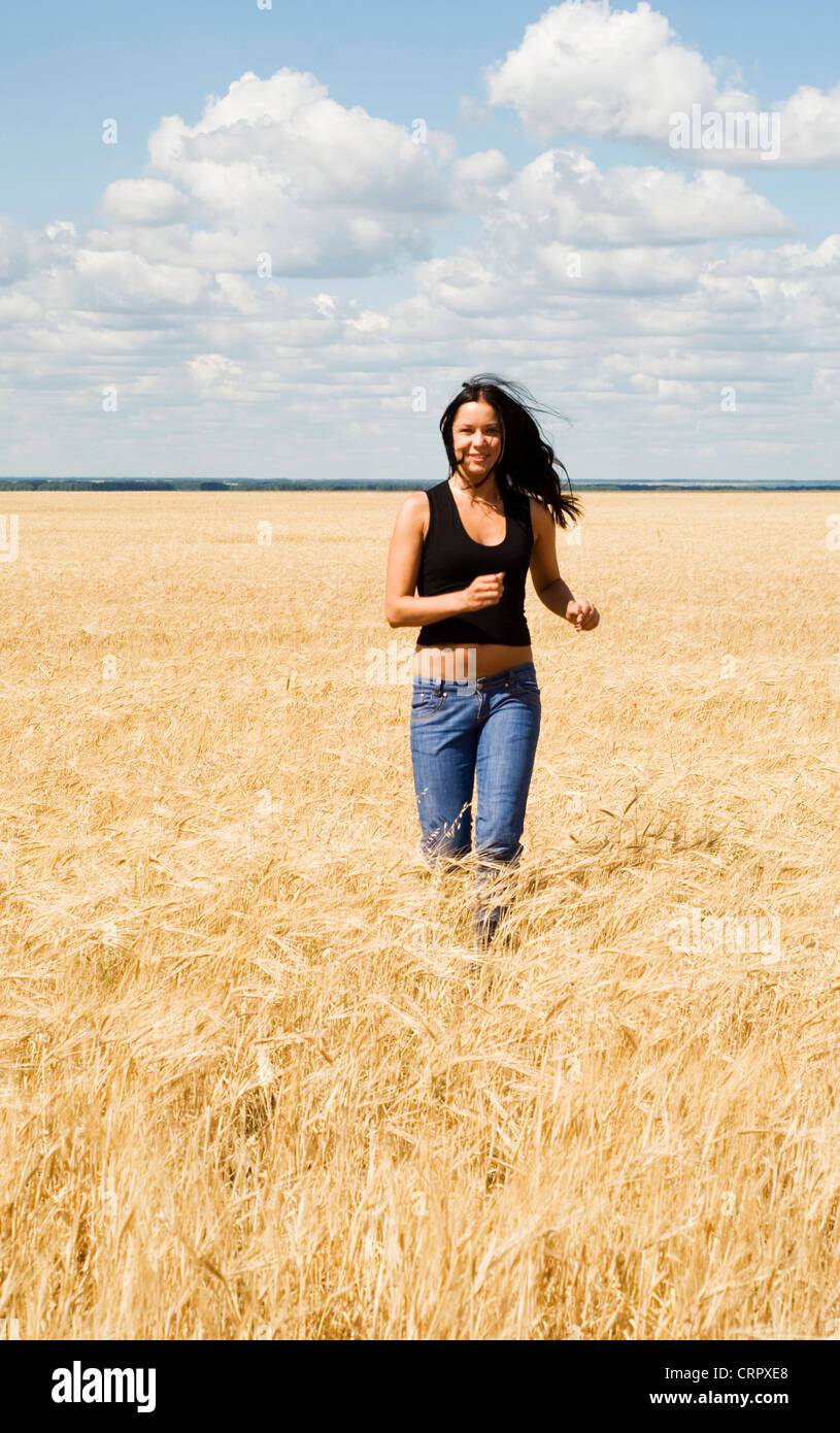 beautiful running woman on a field Stock Photo - Alamy