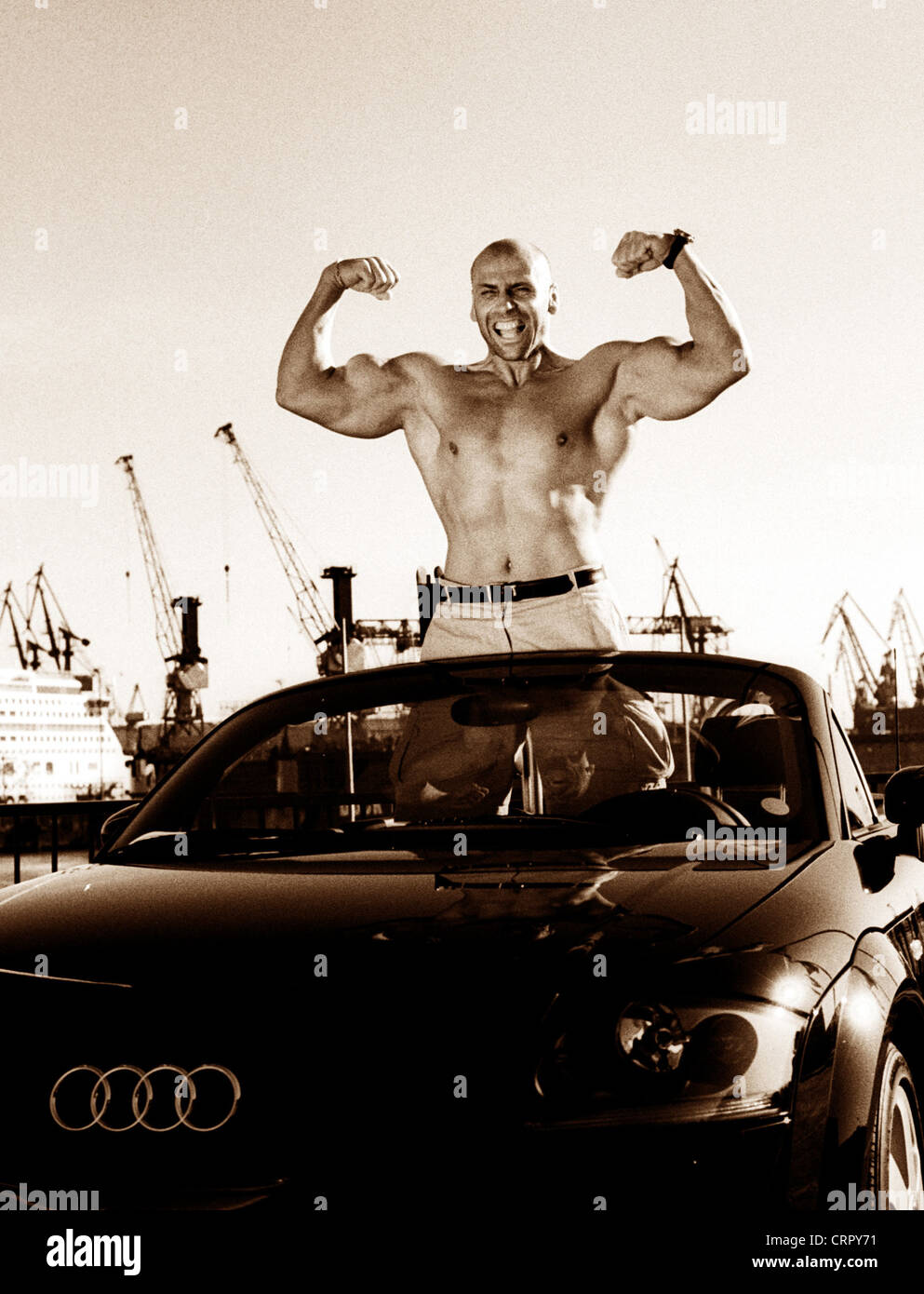 Man is in the car and presents his muscles Stock Photo - Alamy