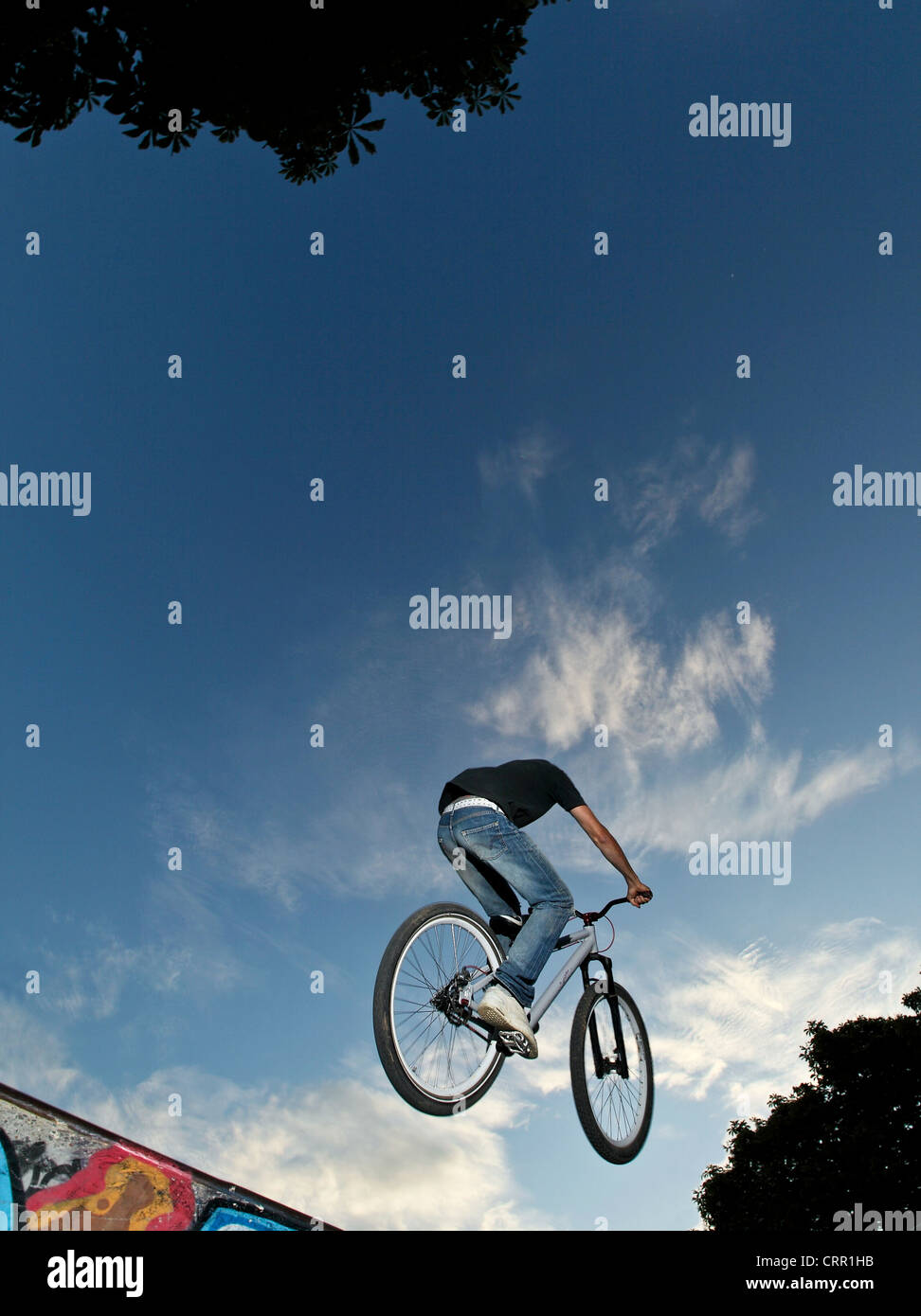 Biker jumping high on a ramp against blue sky Stock Photo - Alamy