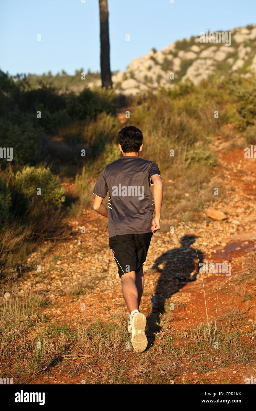 Runner moving through sunlit landscape Stock Photo - Alamy