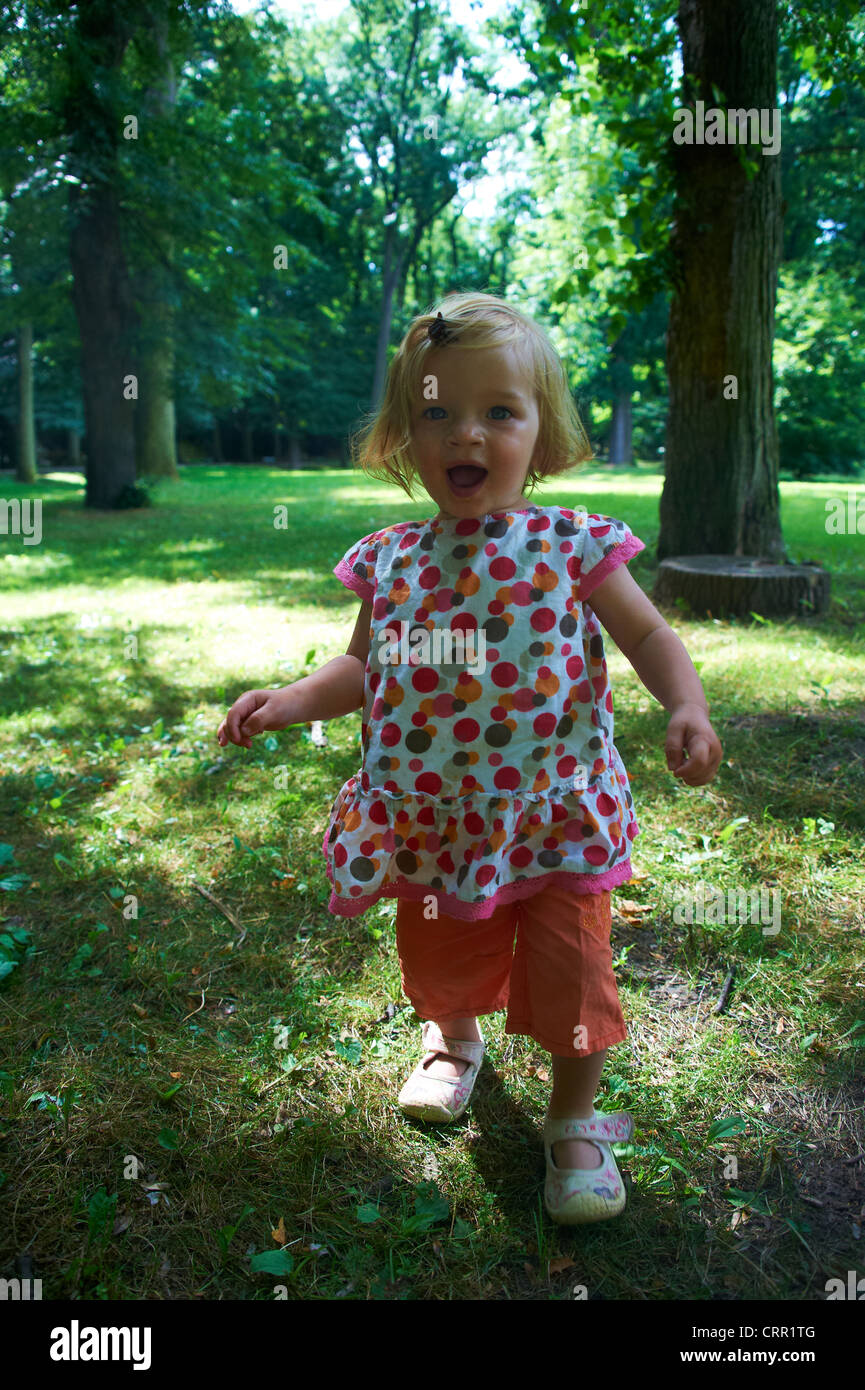Cute little blond child baby girl walking in park Stock Photo - Alamy