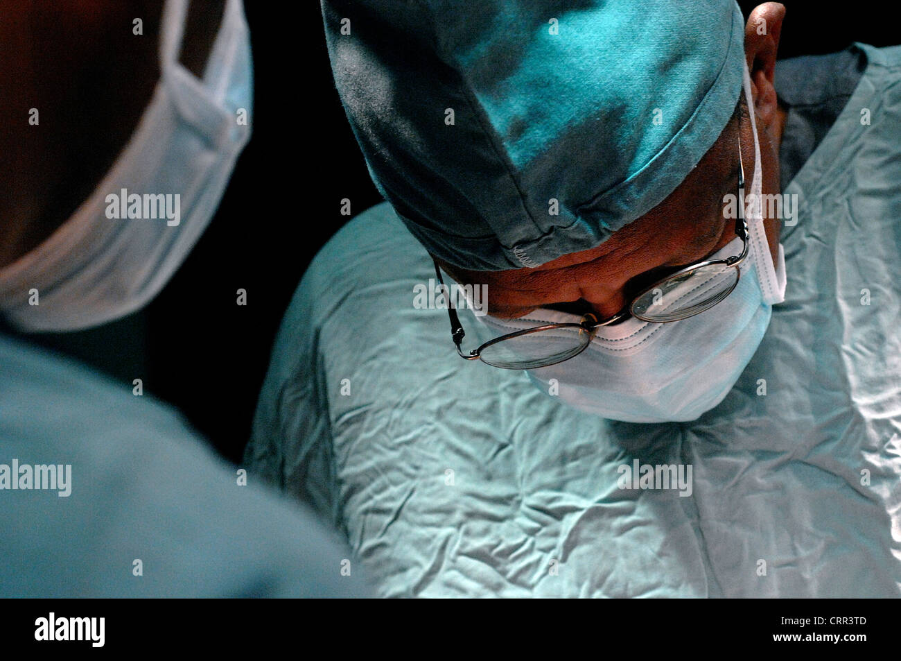 Surgeon and his assistant operating on a patient Stock Photo - Alamy