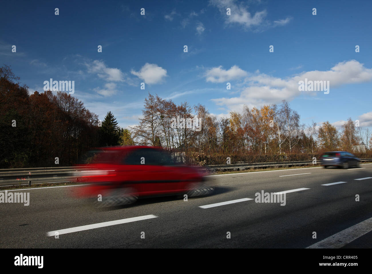 Speeding concept - Cars moving fast on a highway on a lovely autumn ...