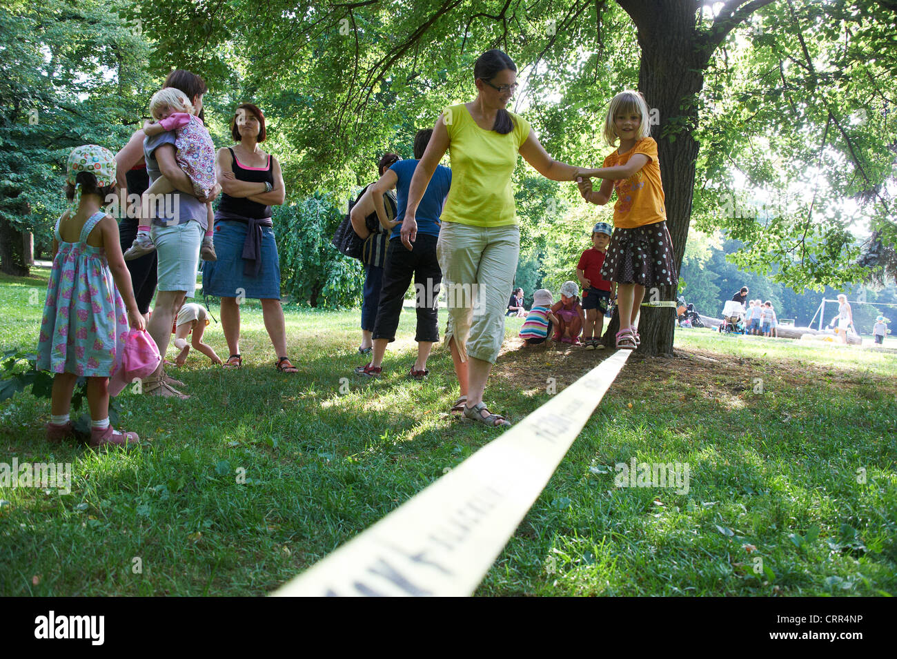 Children and Parents Slacklining in summer park Stock Photo - Alamy