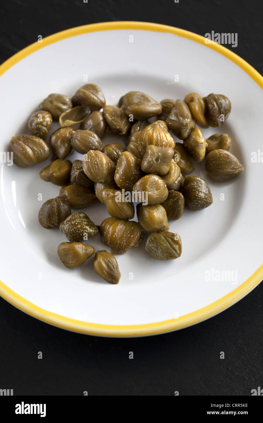 Capers on round plate Stock Photo - Alamy