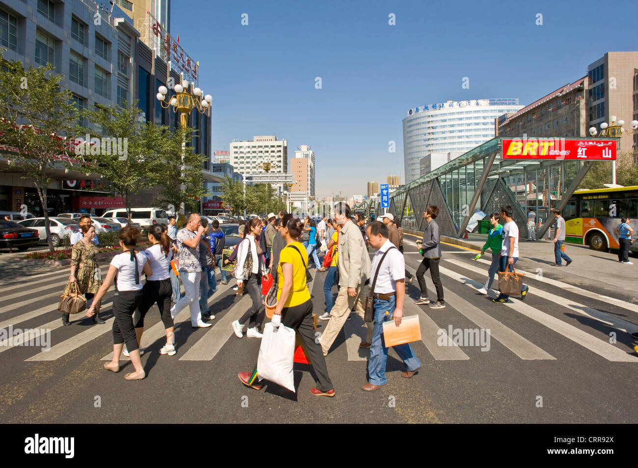Local Chinese people crossing Man Lu street in the center of Urumqi ...