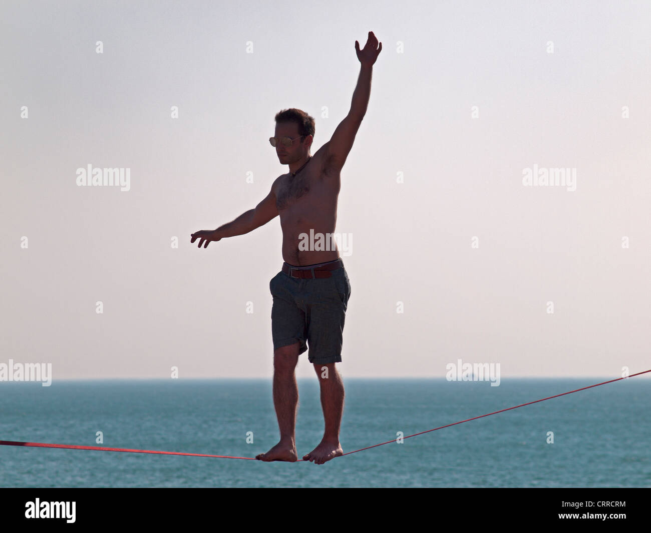 A man walks on a tightrope on Brighton seafront Stock Photo - Alamy