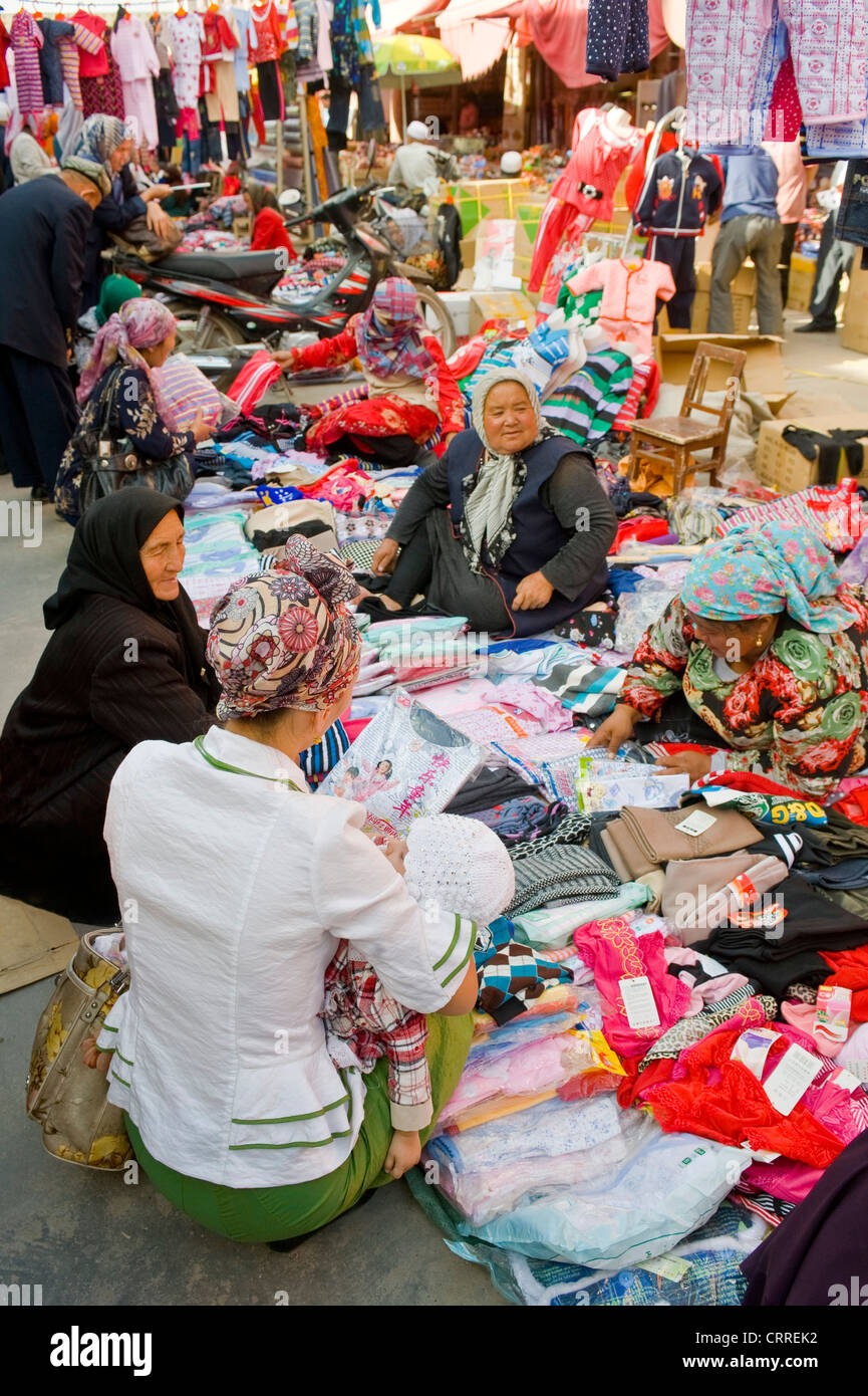 Chinese Uyghur women barter for childrens clothes in the Western ...