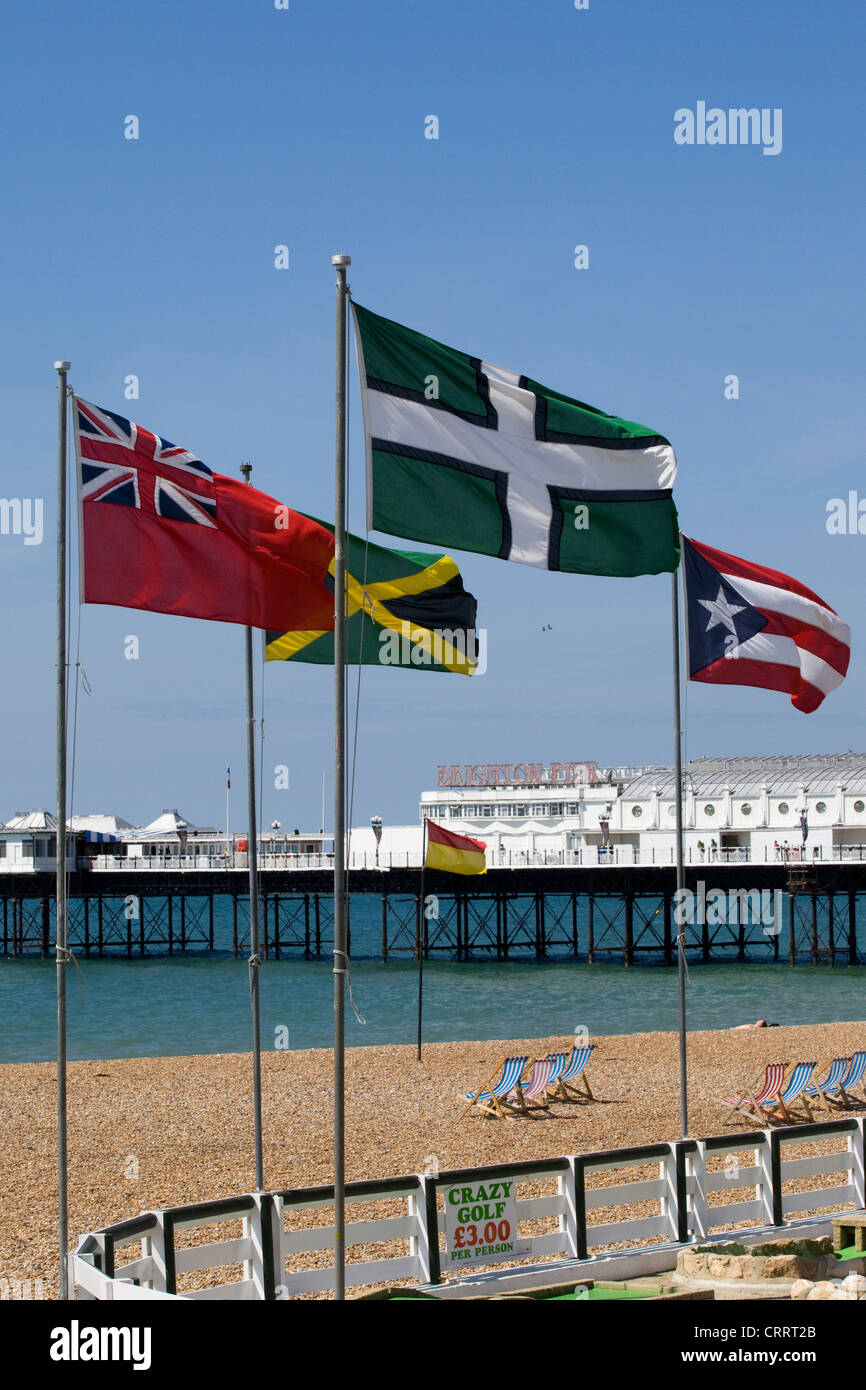 Flags flying the Brighton Pier in the background city of Brighton and ...