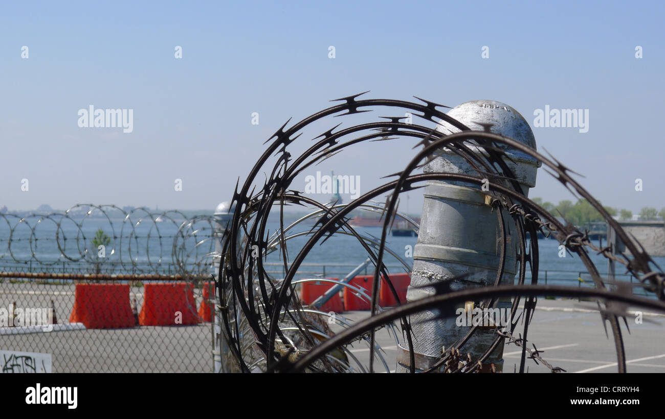 Distant Statue of Liberty framed by razor wire, Red Hook, Brooklyn, New ...